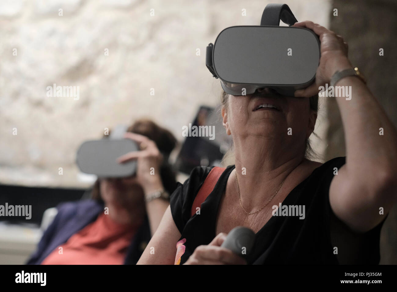 Visitors watching 3D tourist content through virtual reality VR goggles ...