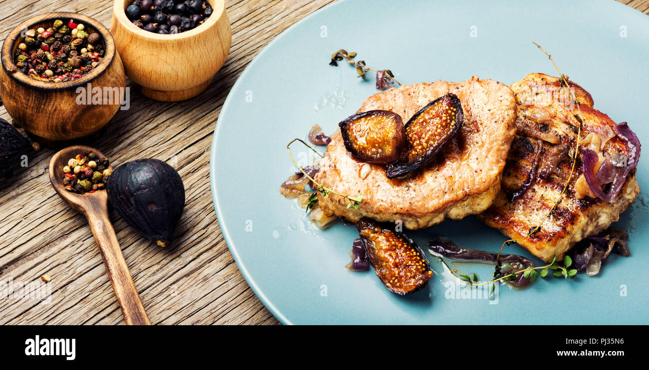 Baked meat with onion and figs on plate.Steak with figs sauce Stock ...