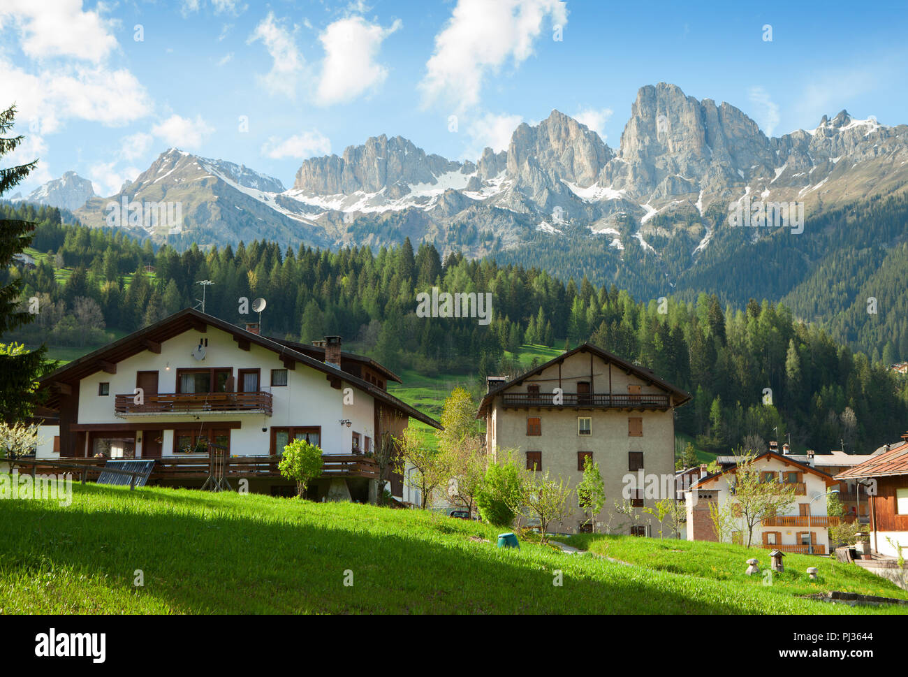 Houses are surrounded by the Dolomites, Comune di Falcade, Italy. View ...