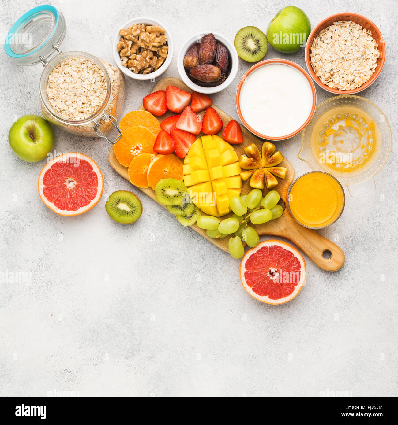Healthy breakfast with oats, variety of fruits, strawberries, mango ...