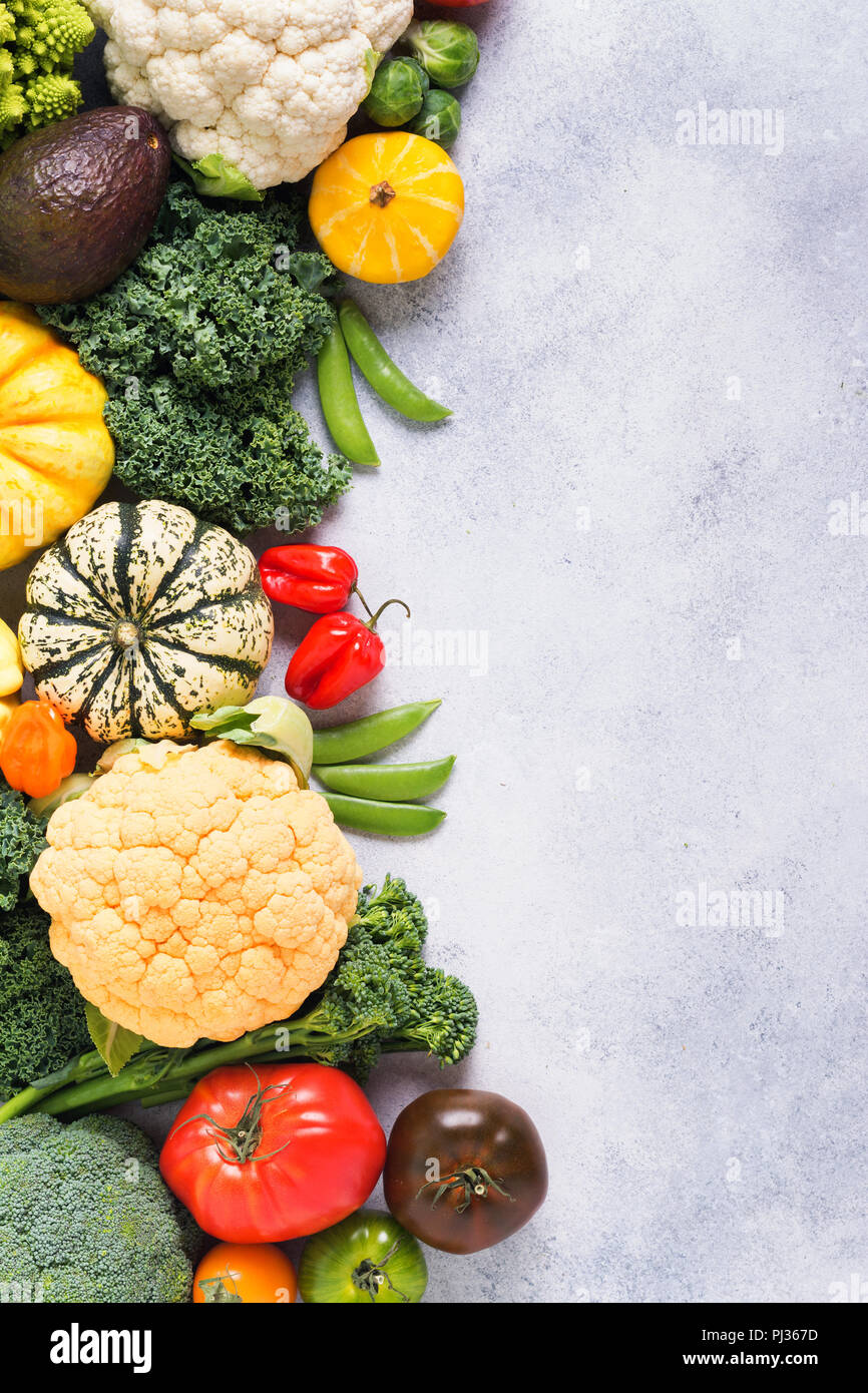 Above view of different colored rainbow vegetables on the light grey ...