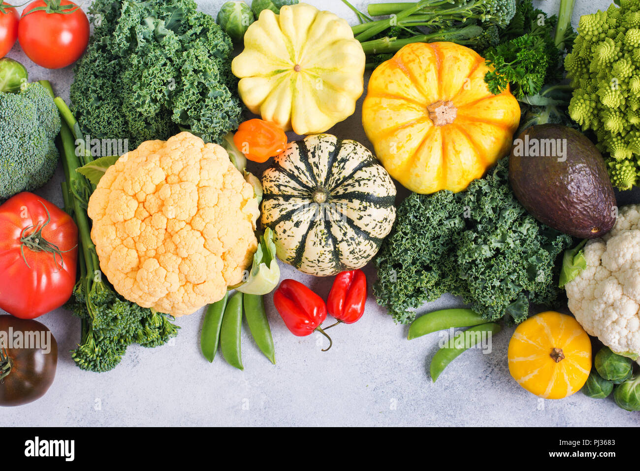 Above view of assorted colored rainbow vegetables on the light grey ...