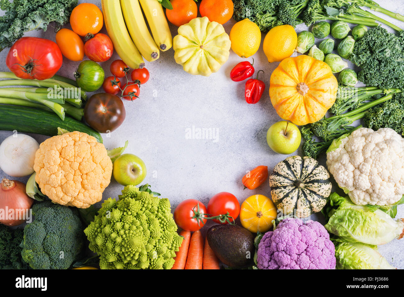 Assorted colorful vegetables arranged in a circle on the light grey ...