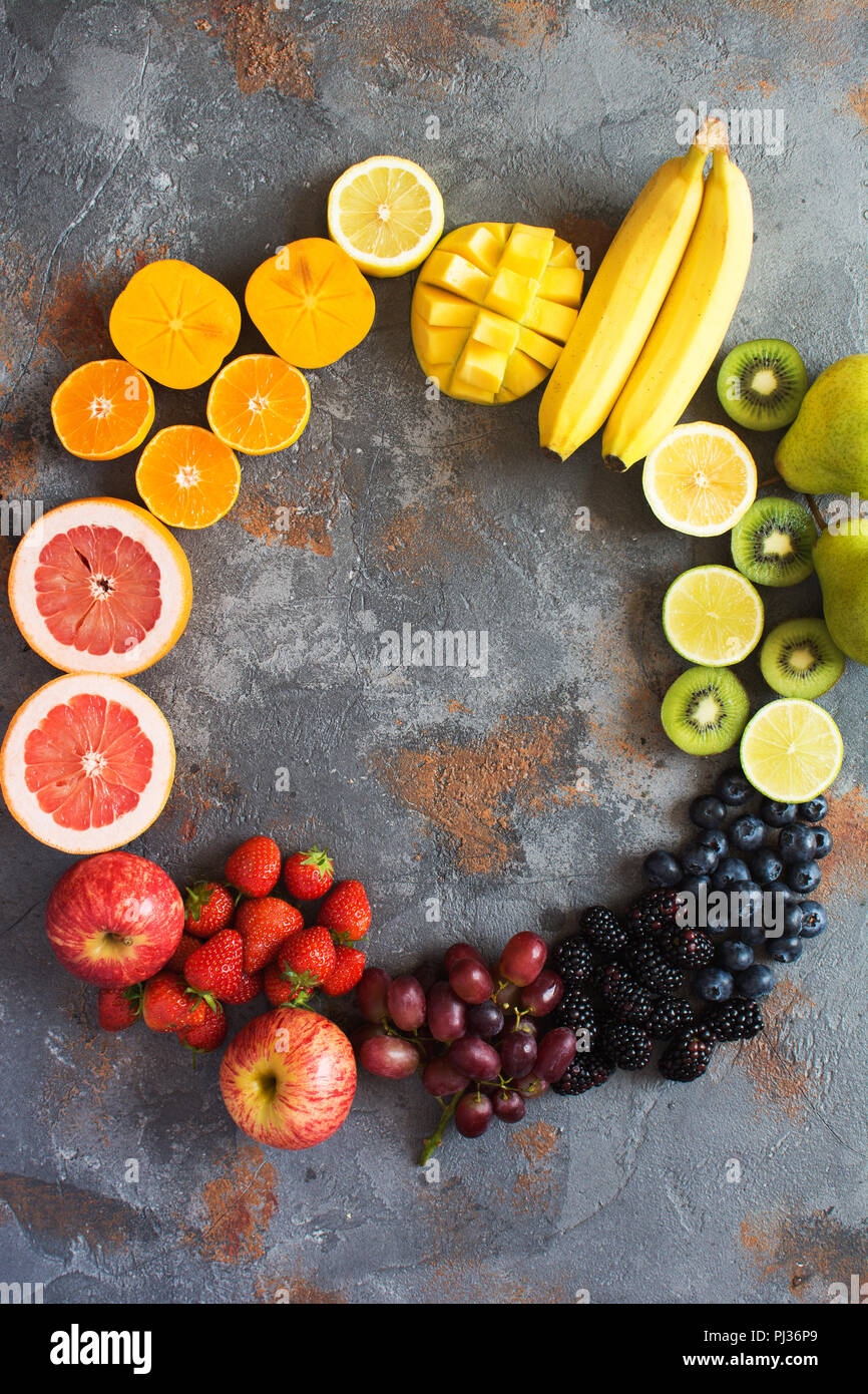 Rainbow colored fruits in a circle, strawberries, blueberries, mango ...