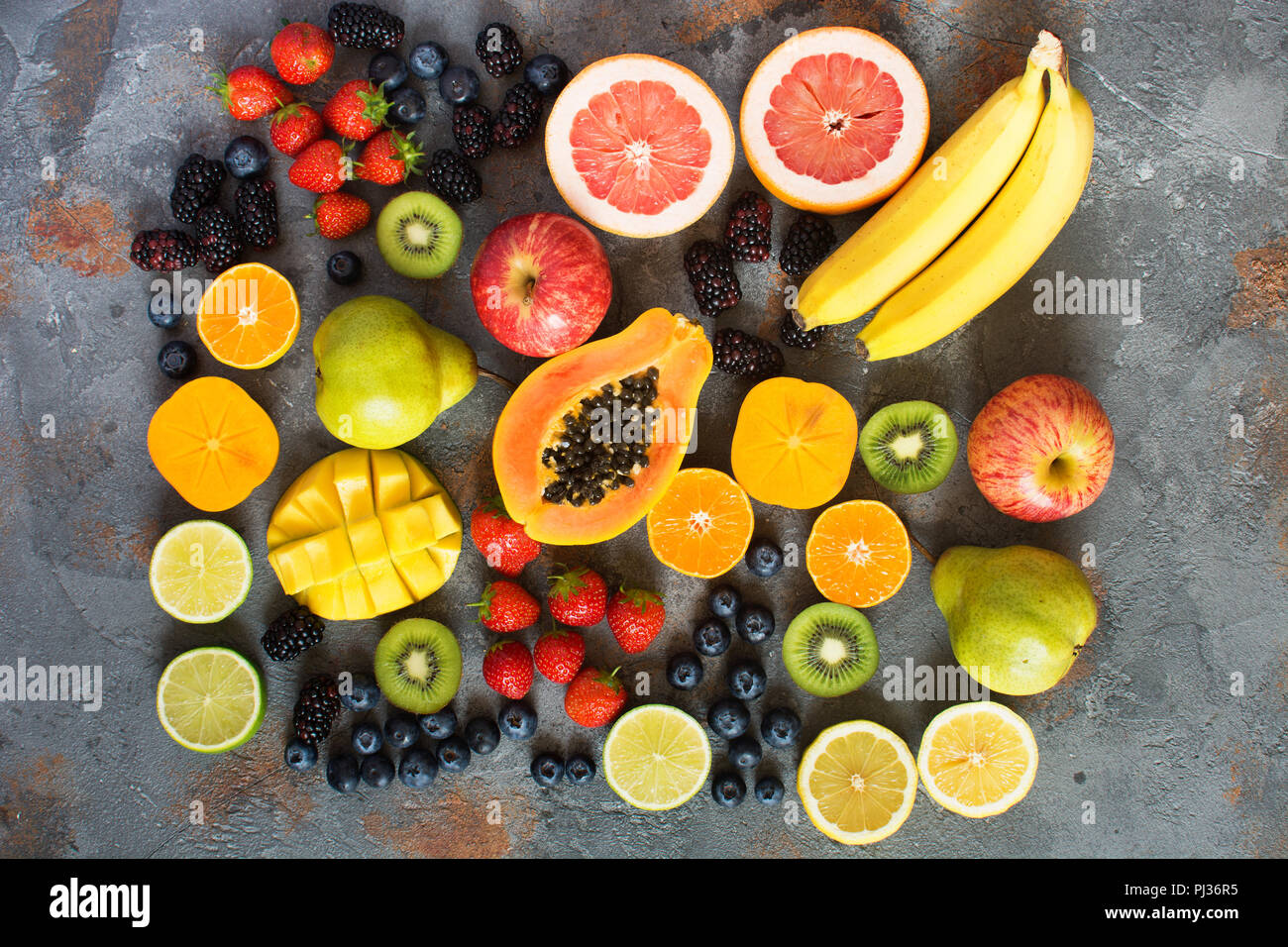 Different rainbow colored fruits, strawberries, blueberries, mango ...