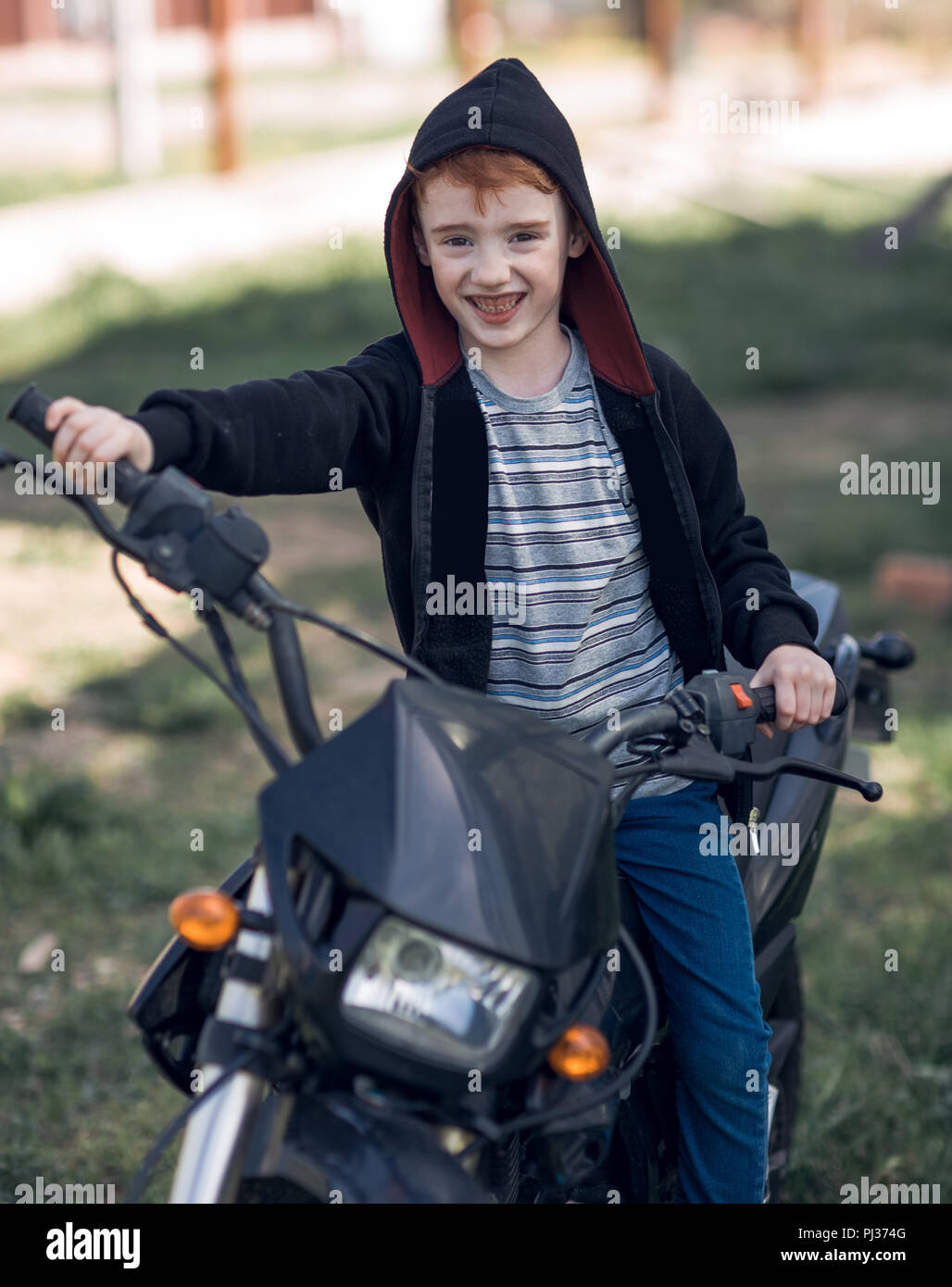 smiling little biker riding a motorcycle Stock Photo - Alamy
