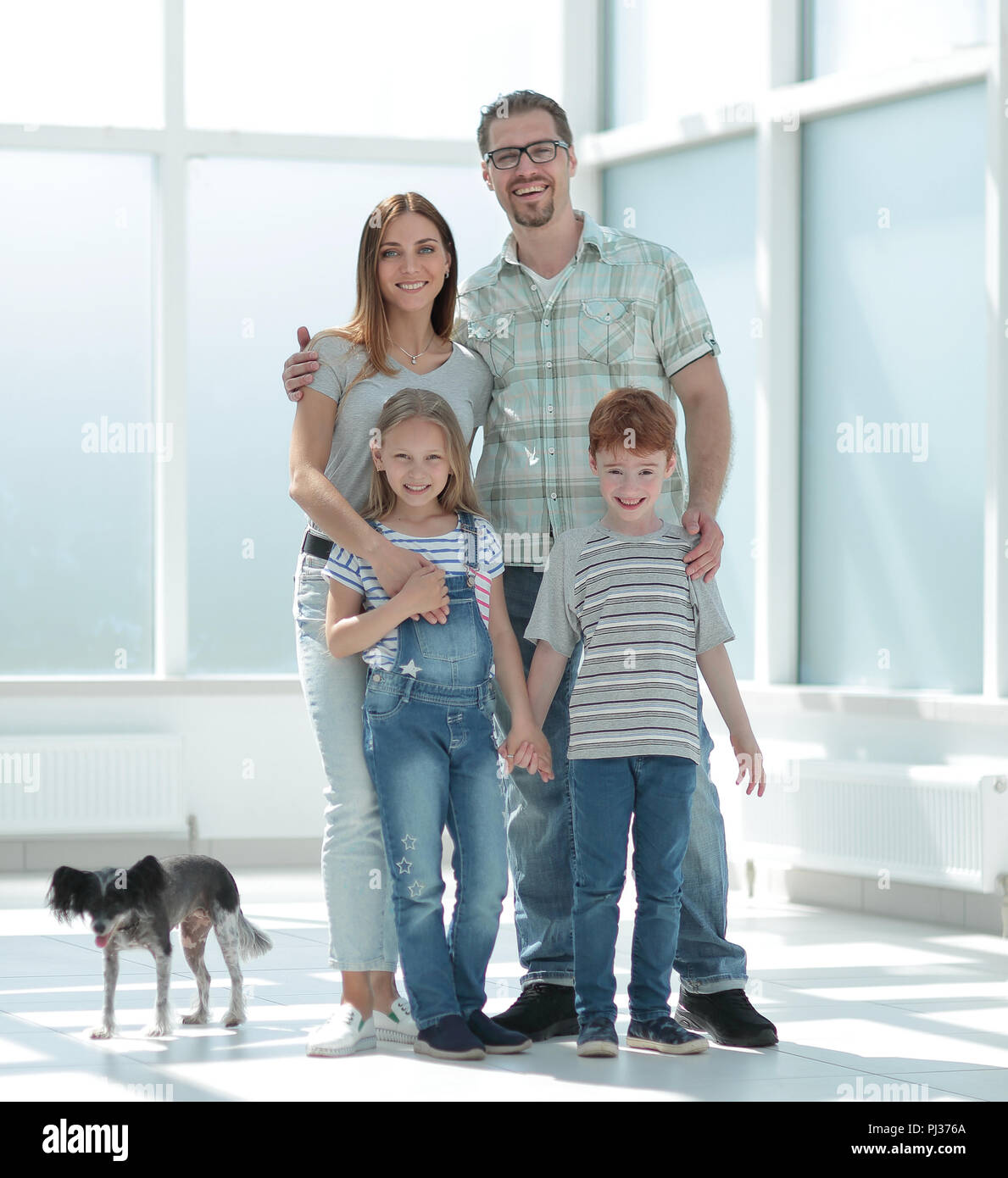 family with two children standing in a new house Stock Photo - Alamy