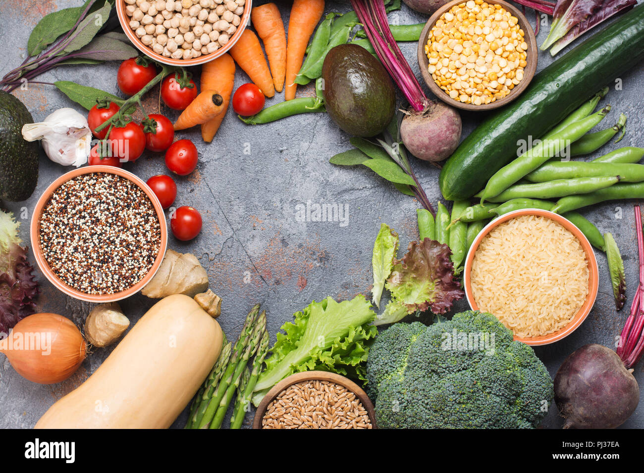 Grains in bowls and vegetables arranged in a circle with copy space in ...