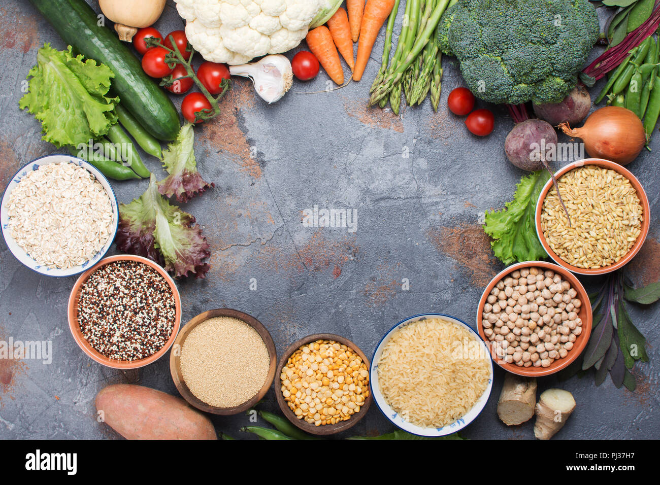 Grains in a bowl and vegetables arranged in a circle with copy space in ...