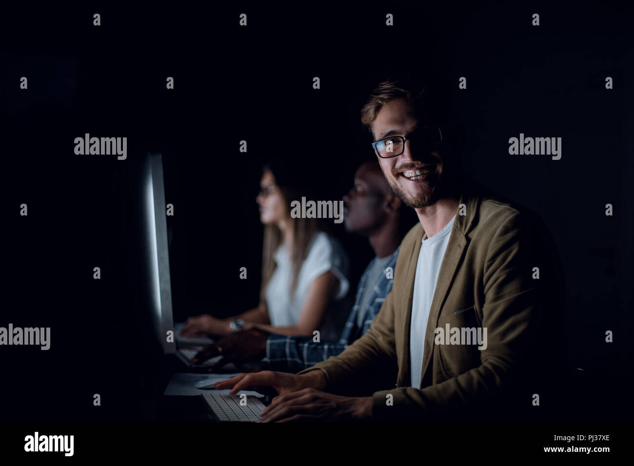 smiling employee working in the office at night Stock Photo - Alamy