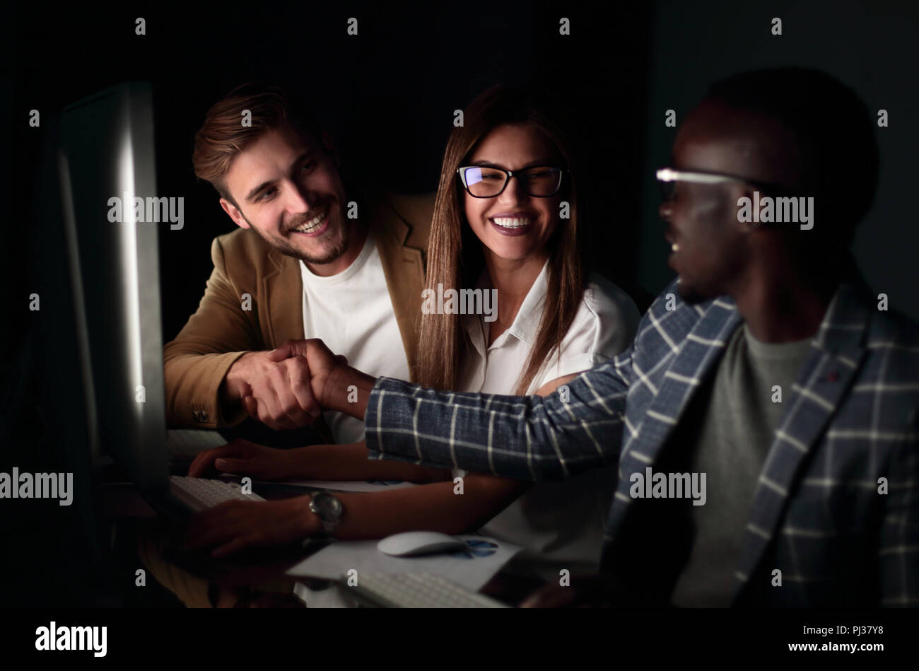employees shake hands while sitting at the Desk Stock Photo - Alamy