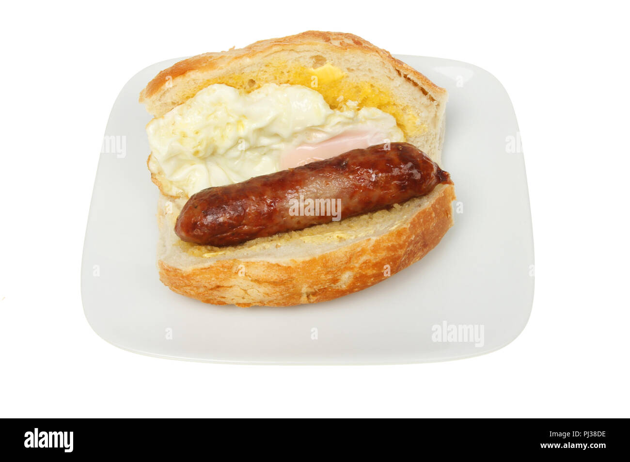 Sausage and fried egg in a giraffe bread roll on a plate isolated ...