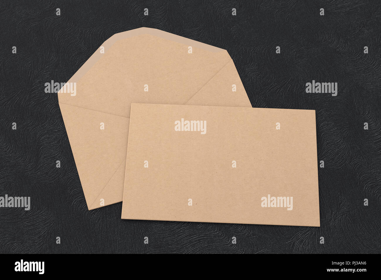 Craft paper blank closed envelope on opened envelope on black ...
