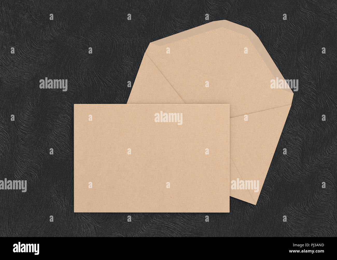 Craft paper blank closed envelope on opened envelope on black ...