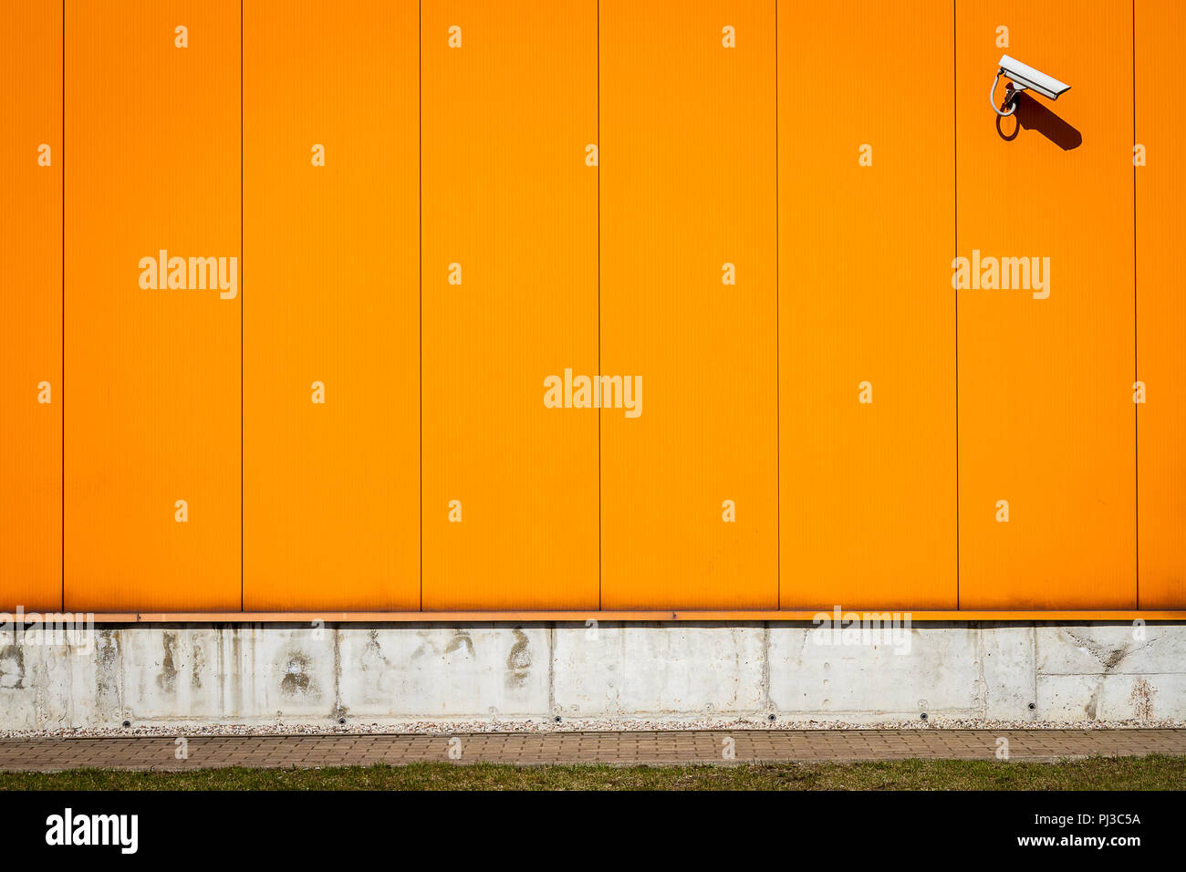 Orange wall of the building, warehouse and the security camera ...
