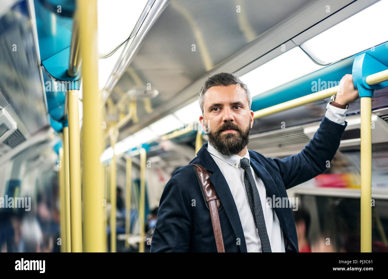 Hipster businessman inside the subway in the city, travelling to work ...