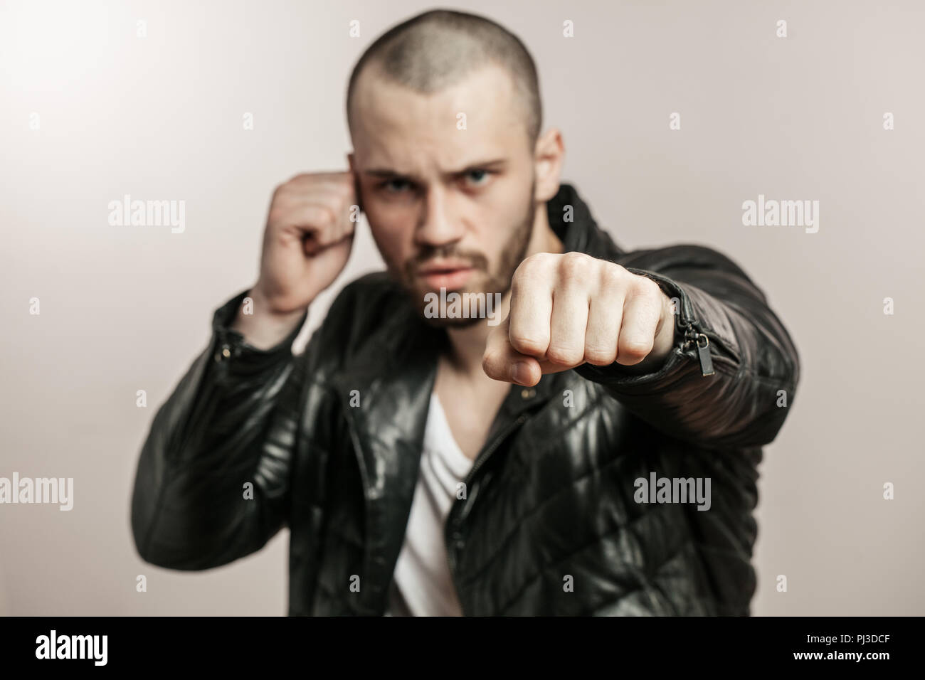 . fashion man in leather black jacket dealing a strike Stock Photo - Alamy