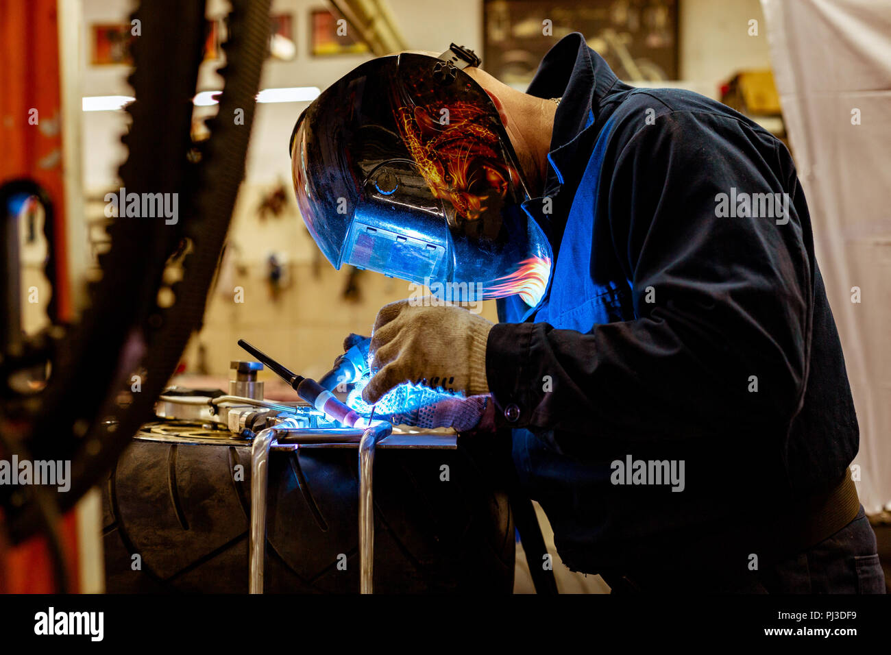Professional car mechanic working in auto repair service on argon gas ...