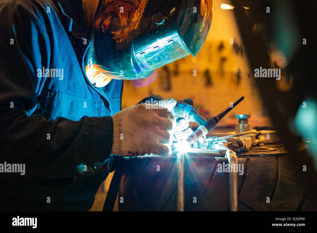 Professional car mechanic working in auto repair service on argon gas ...