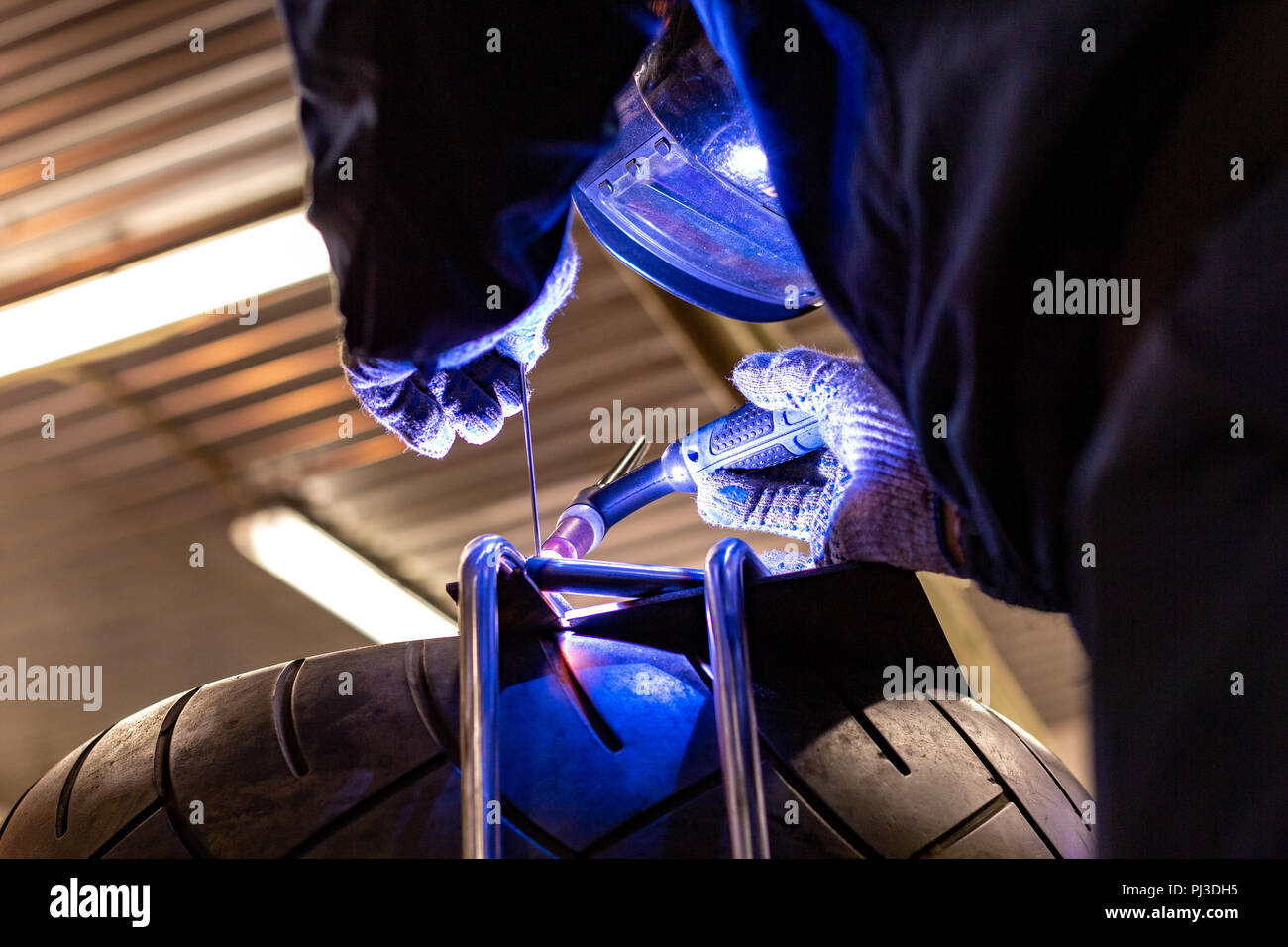 Professional car mechanic working in auto repair service on argon gas ...