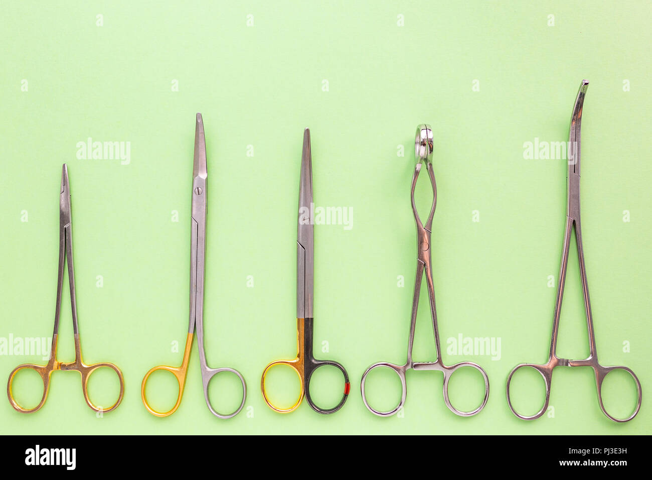 Medical equipments including surgical instruments on a green background ...
