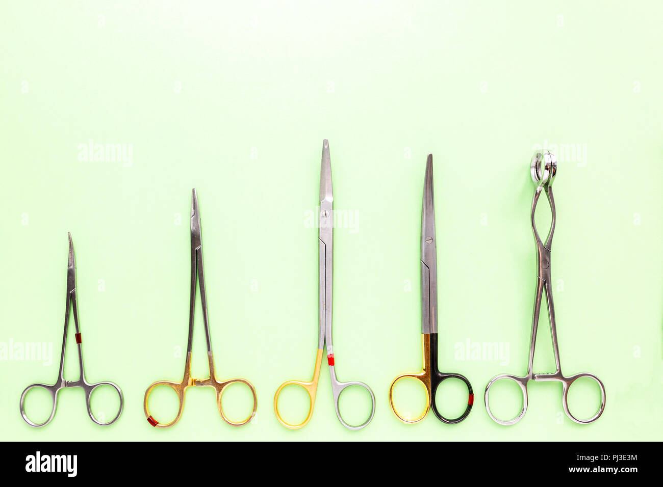 Medical equipments including surgical instruments on a green background ...