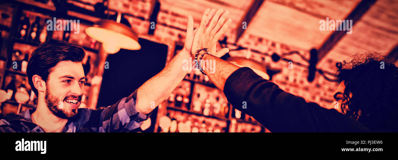 Two young men giving high five to each other Stock Photo - Alamy