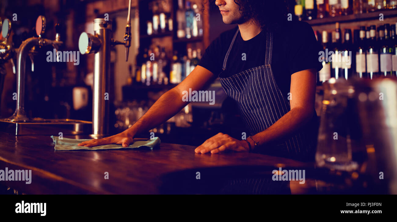 Young waiter cleaning a counter Stock Photo - Alamy