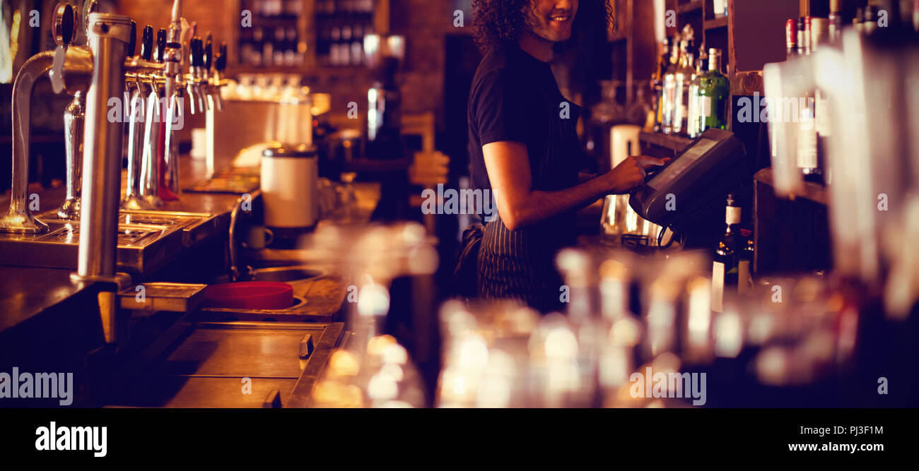 Young waiter using a electronic machine Stock Photo - Alamy