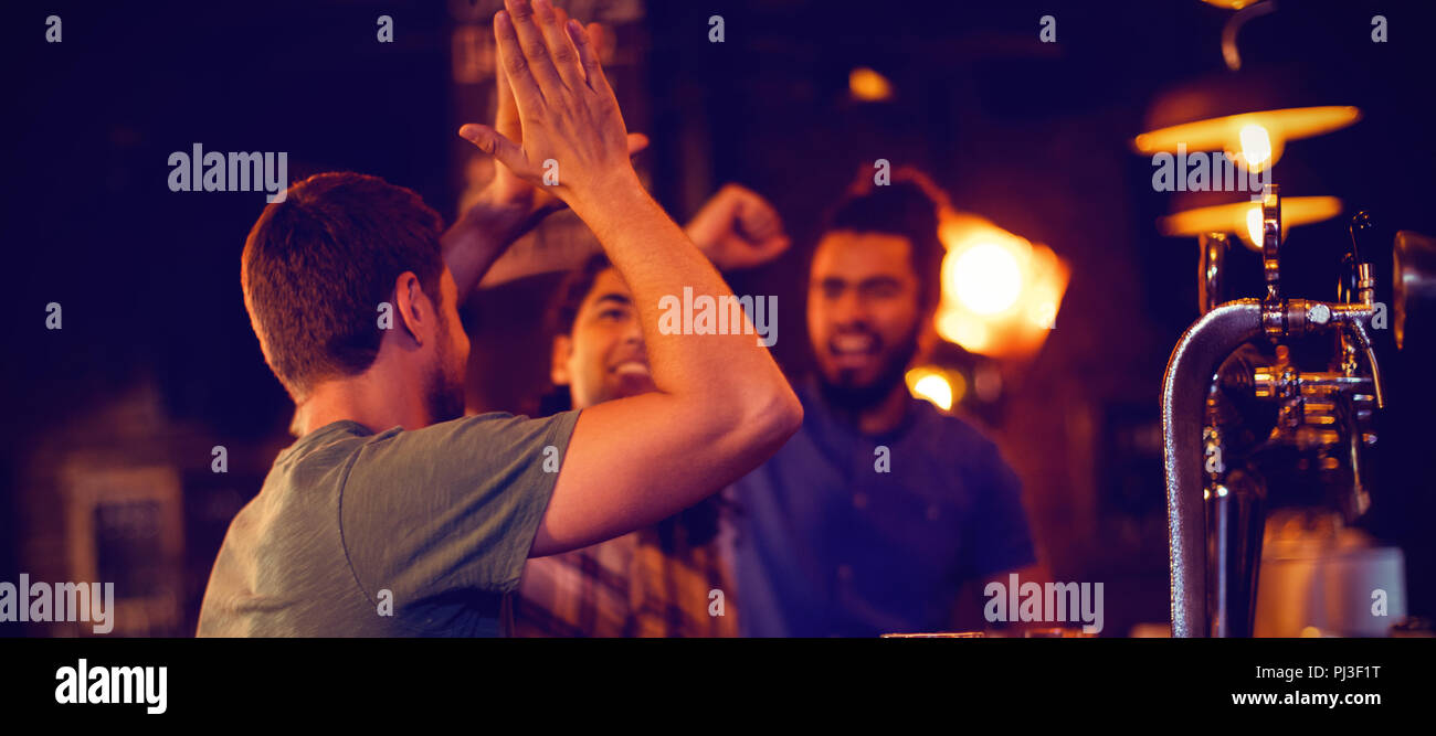 Smiling male friends and high five hi-res stock photography and images ...