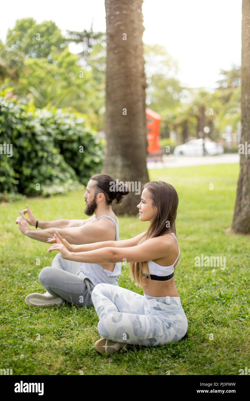 Young couple doing yoga outdoors Stock Photo - Alamy