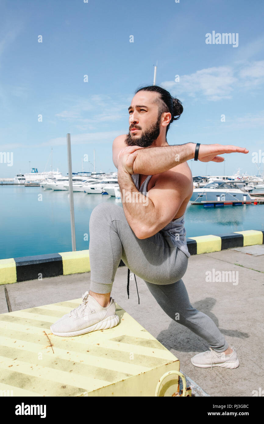 sportsman stretching legs while standing at the beach Stock Photo - Alamy