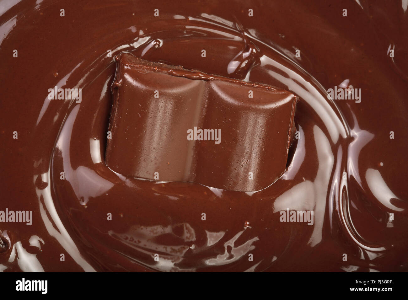 Melted chocolate and pieces of chocolate bar as a background closeup ...