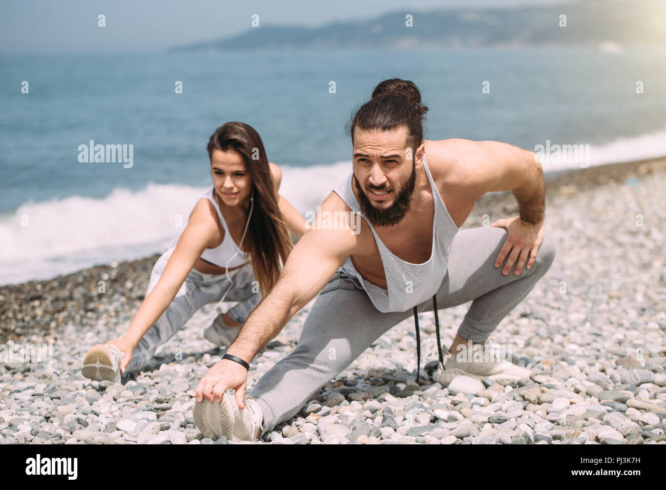 Stretching before everyday jogging on the beach Stock Photo - Alamy