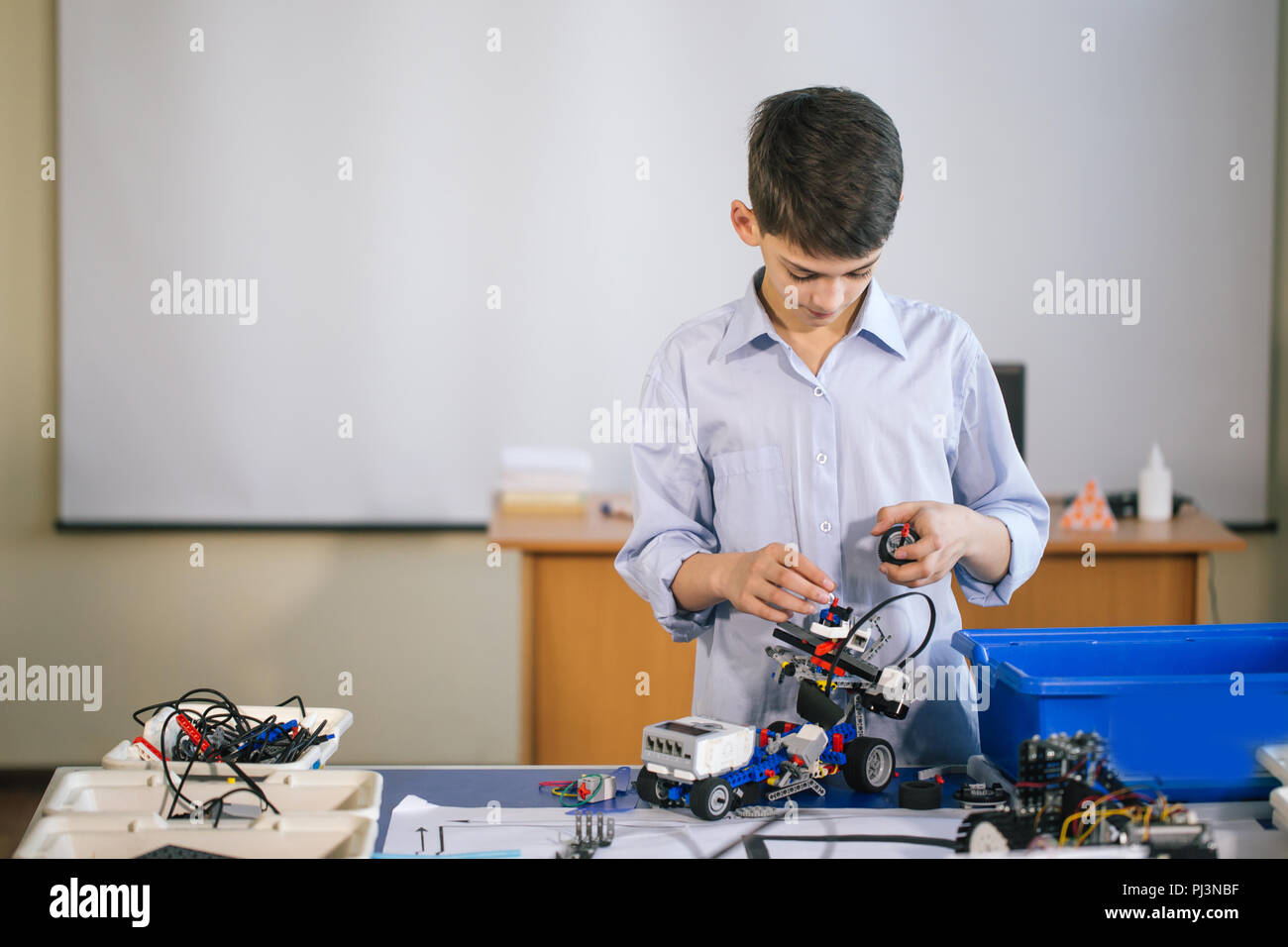 Little boy in robotics school makes robot Stock Photo - Alamy
