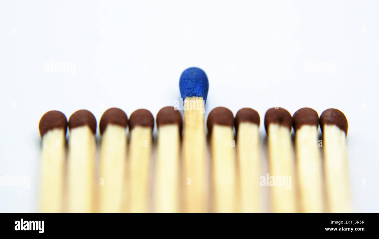 Brown matches with one blue match in the middle Stock Photo - Alamy