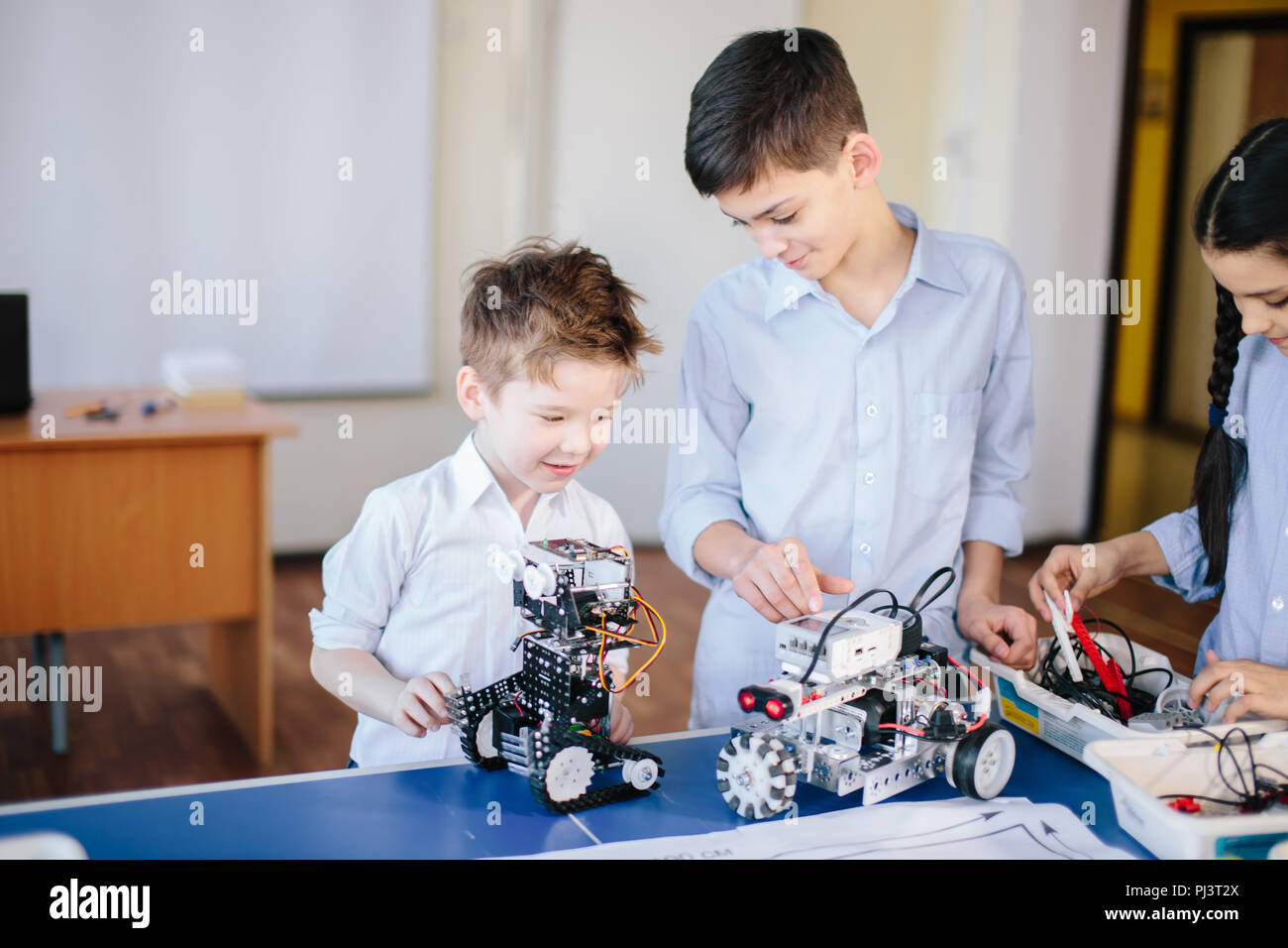Kids playing with electrical robot while visiting robotics exhibition ...