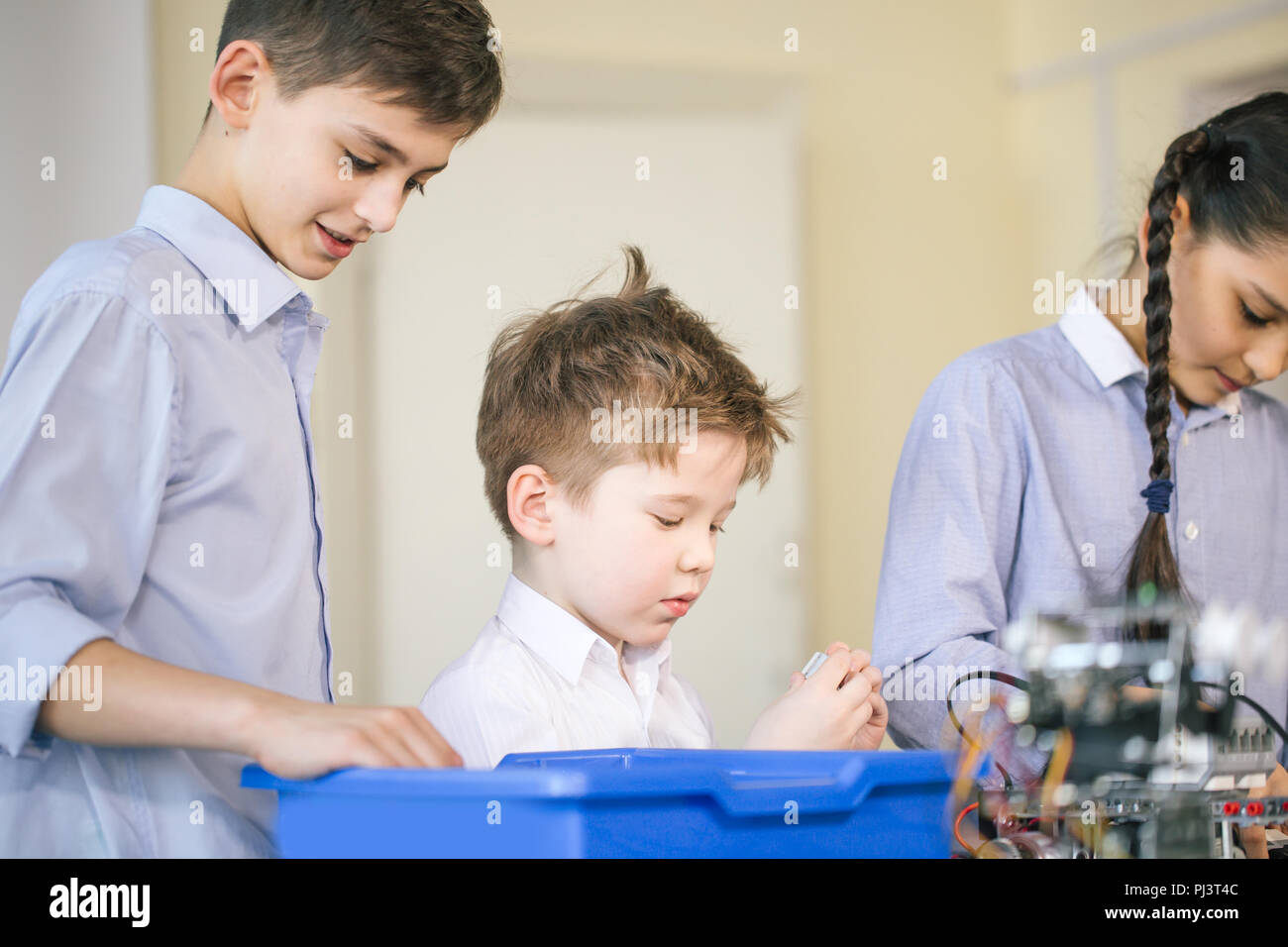 Kids playing with electrical robot while visiting robotics exhibition ...