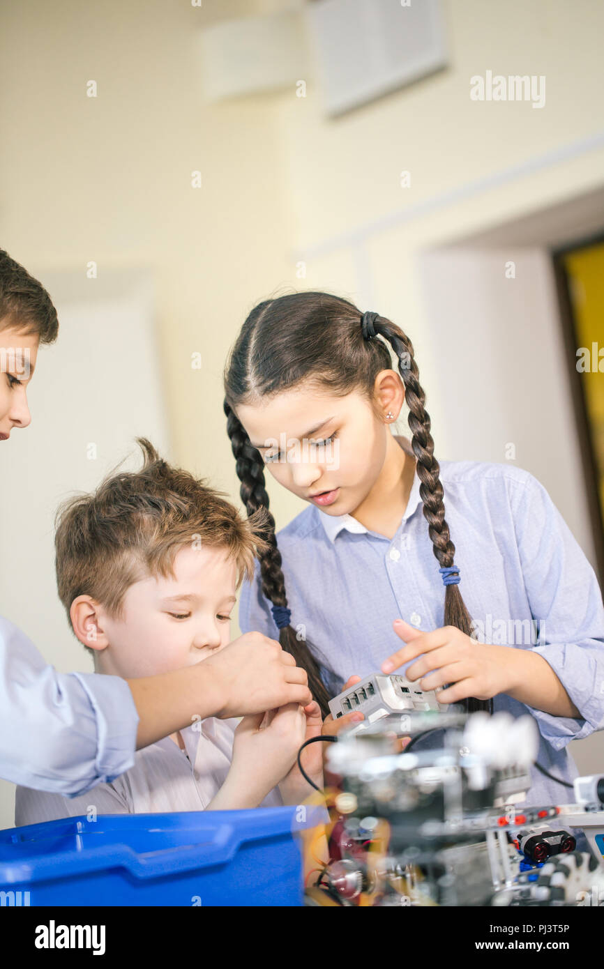 Kids playing with electrical robot while visiting robotics exhibition ...