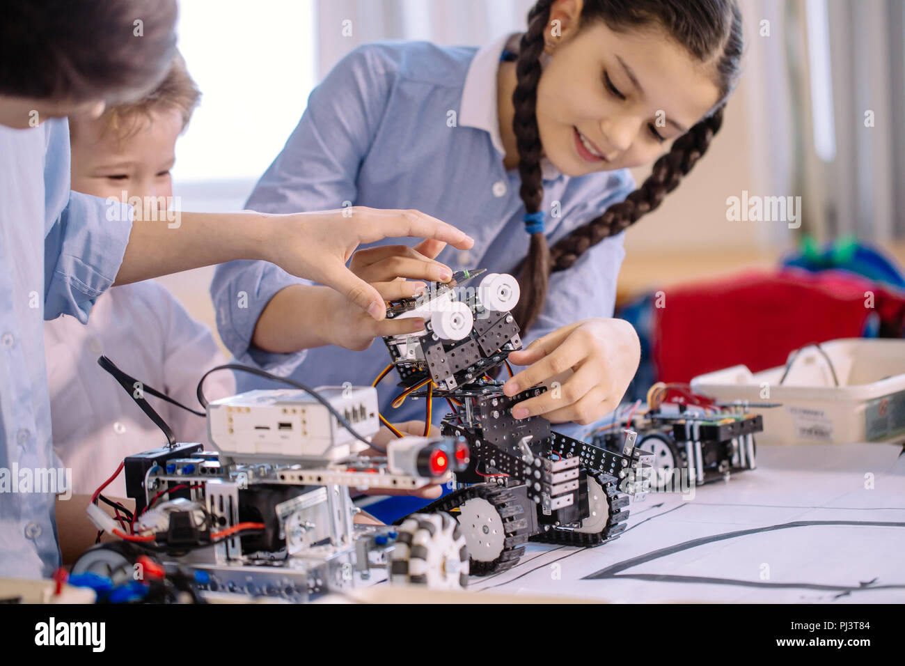 Kids playing with electrical robot while visiting robotics exhibition ...