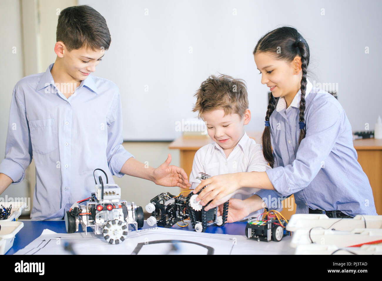 Kids playing with electrical robot while visiting robotics exhibition ...