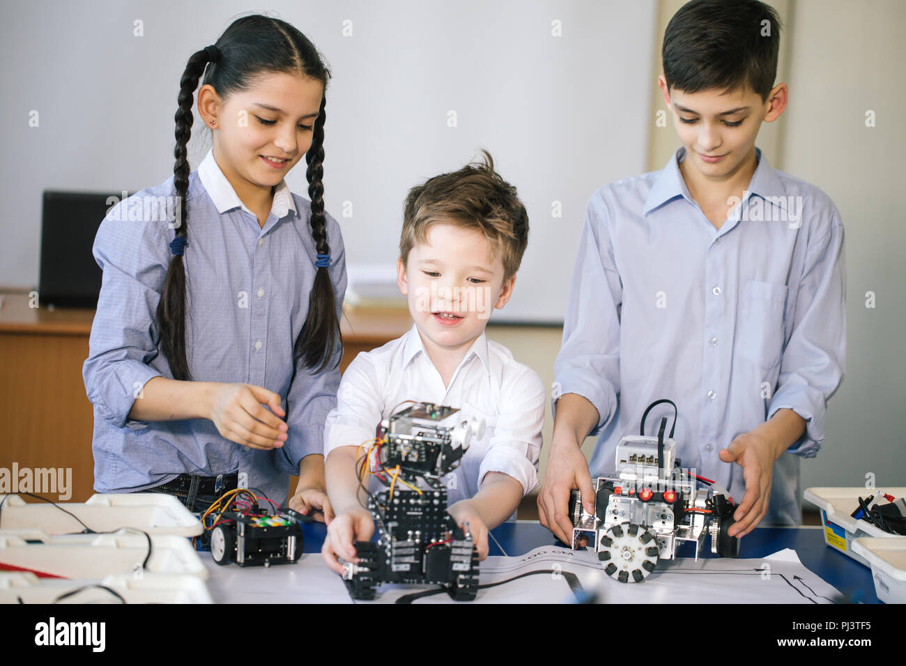 Kids playing with electrical robot while visiting robotics exhibition ...