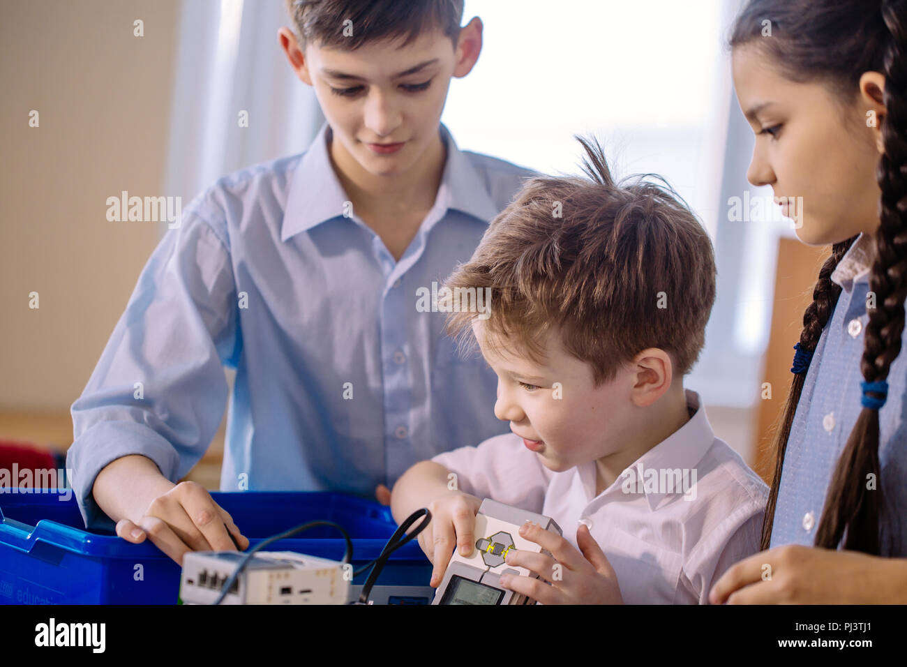 Kids playing with electrical robot while visiting robotics exhibition ...