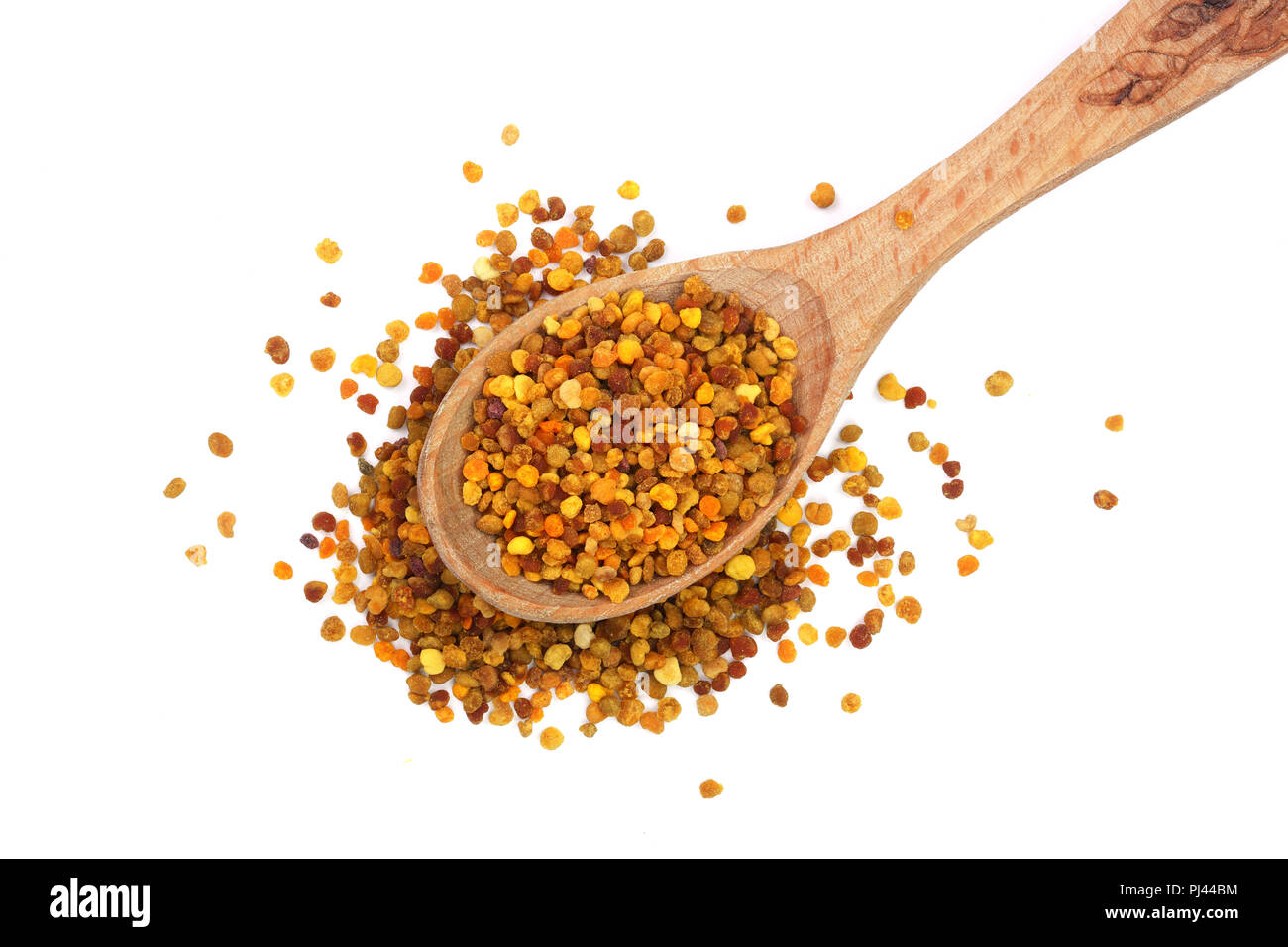 fresh bee pollen in wooden spoon isolated on white background. Top view ...