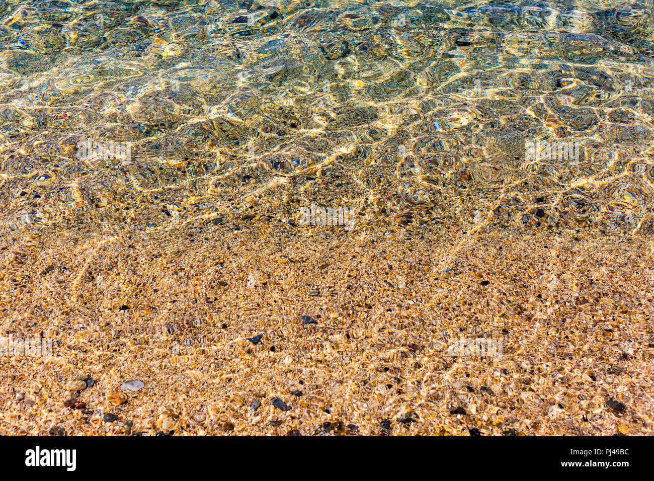 Background of transparent clear water of sea, iridescent sunlight ...