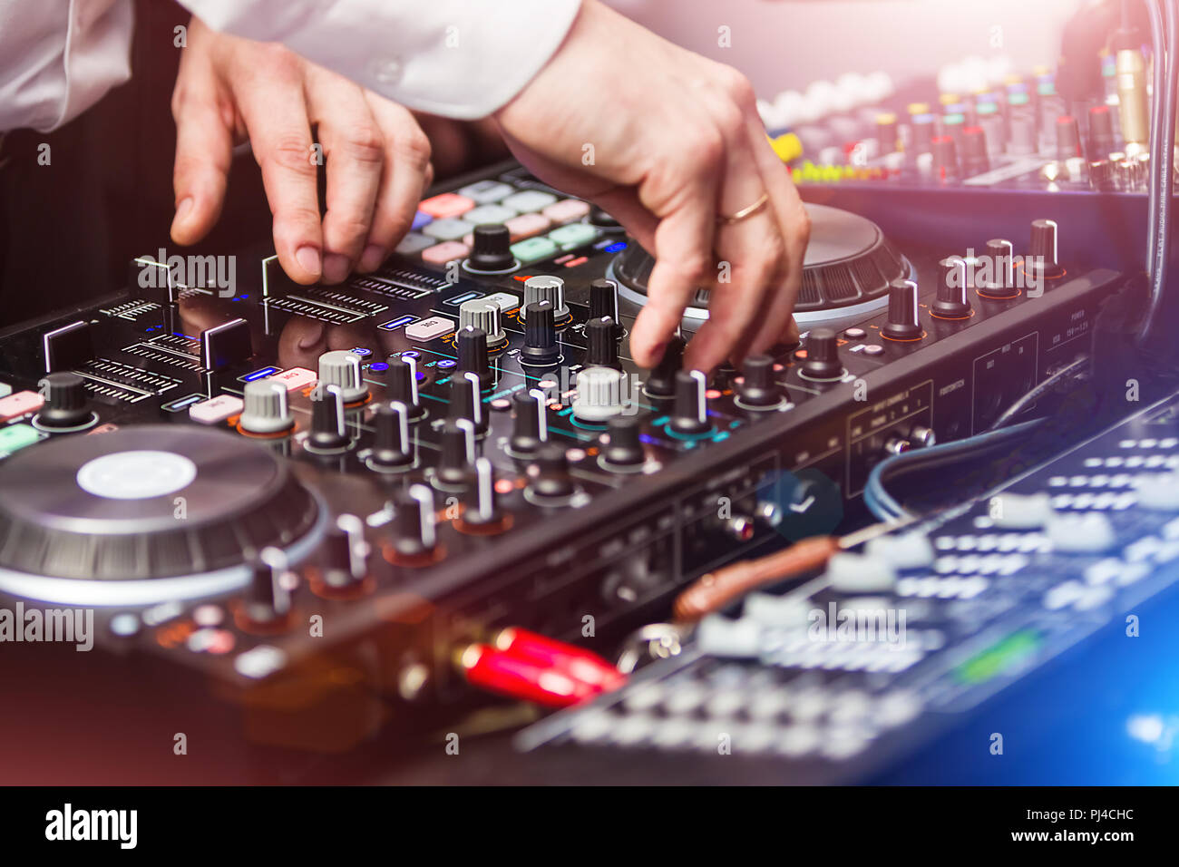 DJ playing music at control panel Stock Photo - Alamy