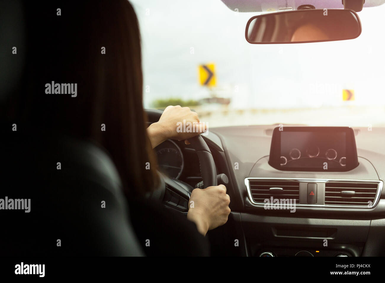 Woman driving car with sign of sharp curves ahead on the road Stock ...