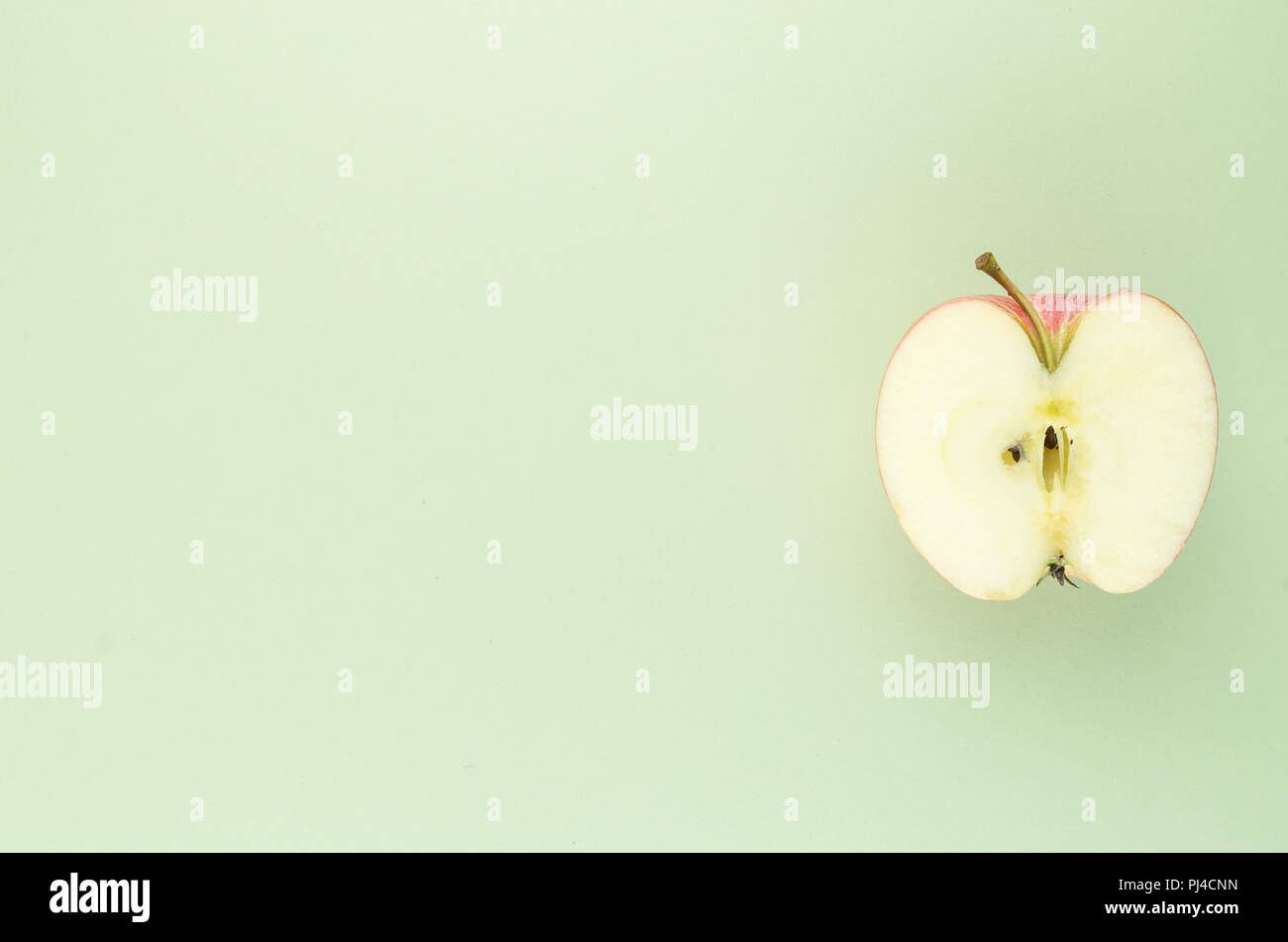 fresh ripe seasonal fruits on a colored paper surface - half apple ...