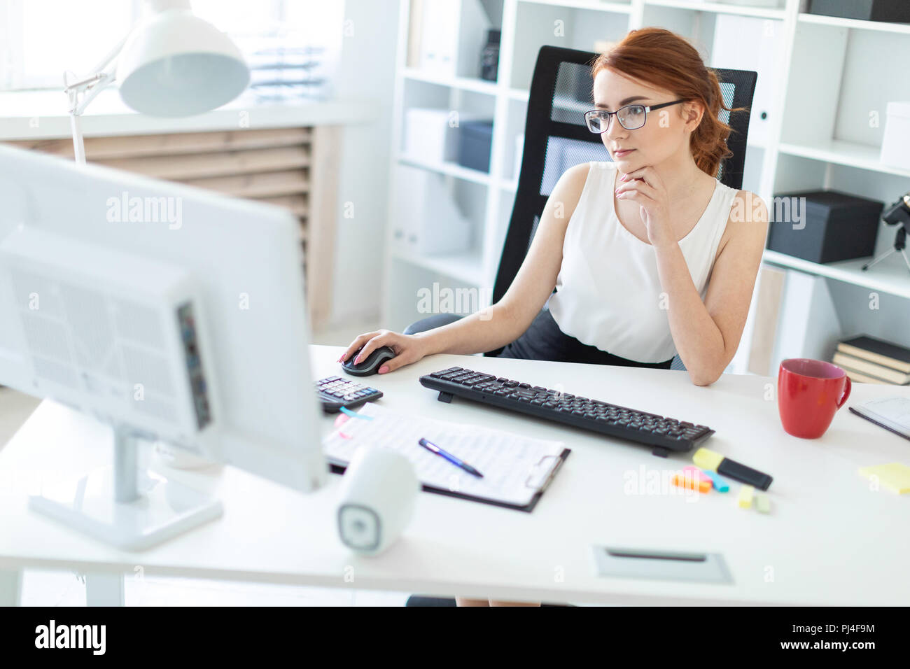 Beautiful young girl in the office working at the computer Stock Photo ...
