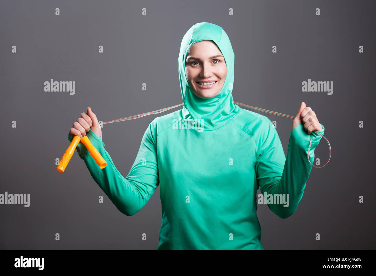 Happy beautiful muslim woman in green hijab or islamic sport wear ...
